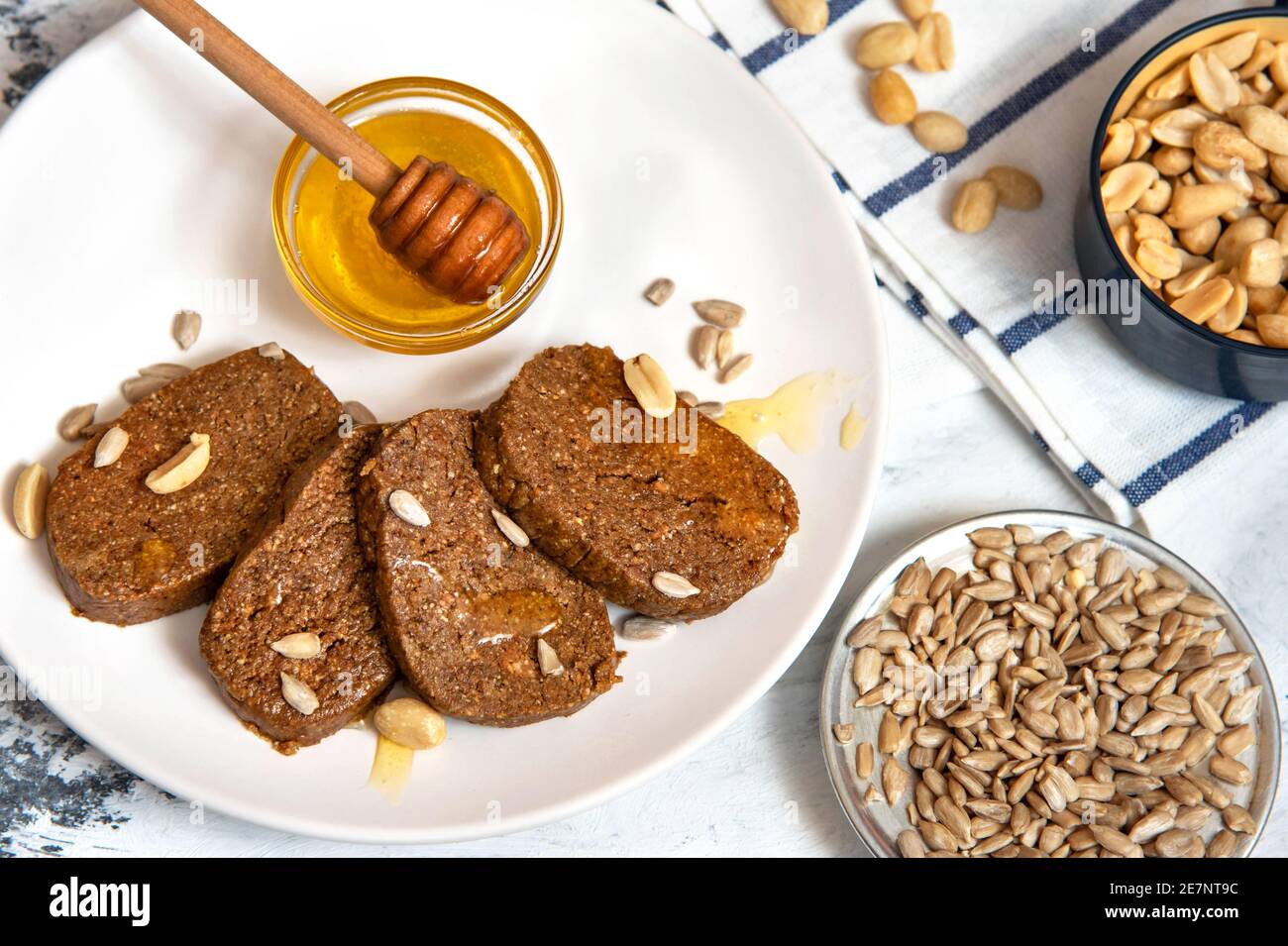 Homemade halva with peanuts and sunflowers watered with honey on a ...