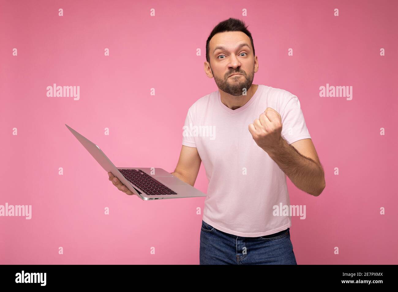 Handsome angry and furious man holding laptop computer showing fist ...