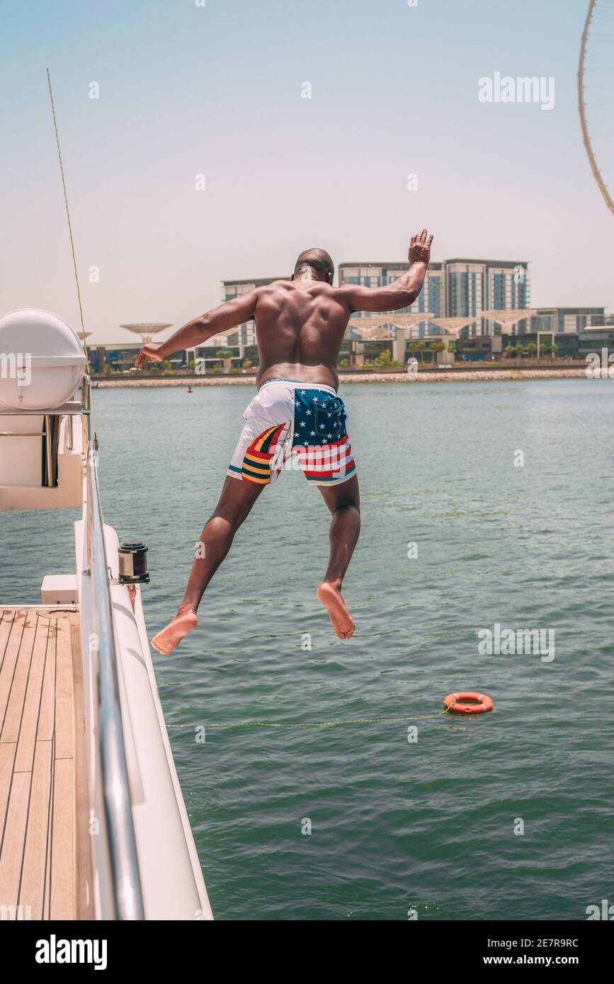 African-American man jumps off from a ship to save someone on the sea ...