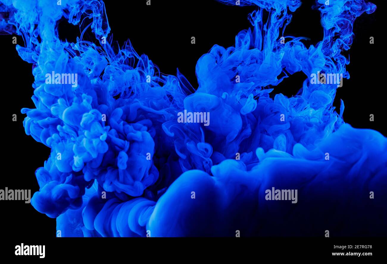Abstract blue ink in water on a black background Stock Photo - Alamy