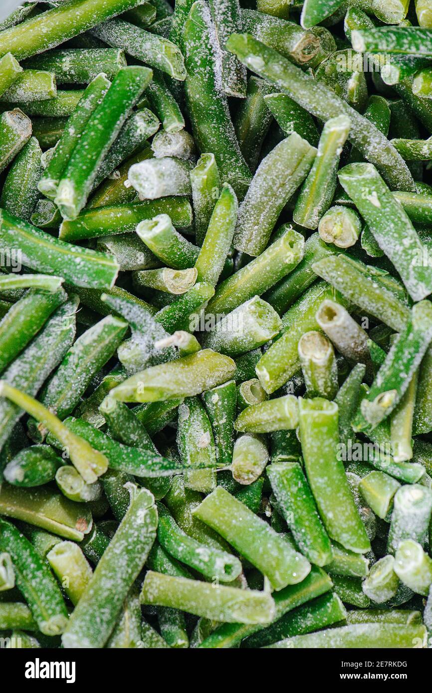 Green beans laid frozen covered with sticky powdered ice. top view ...
