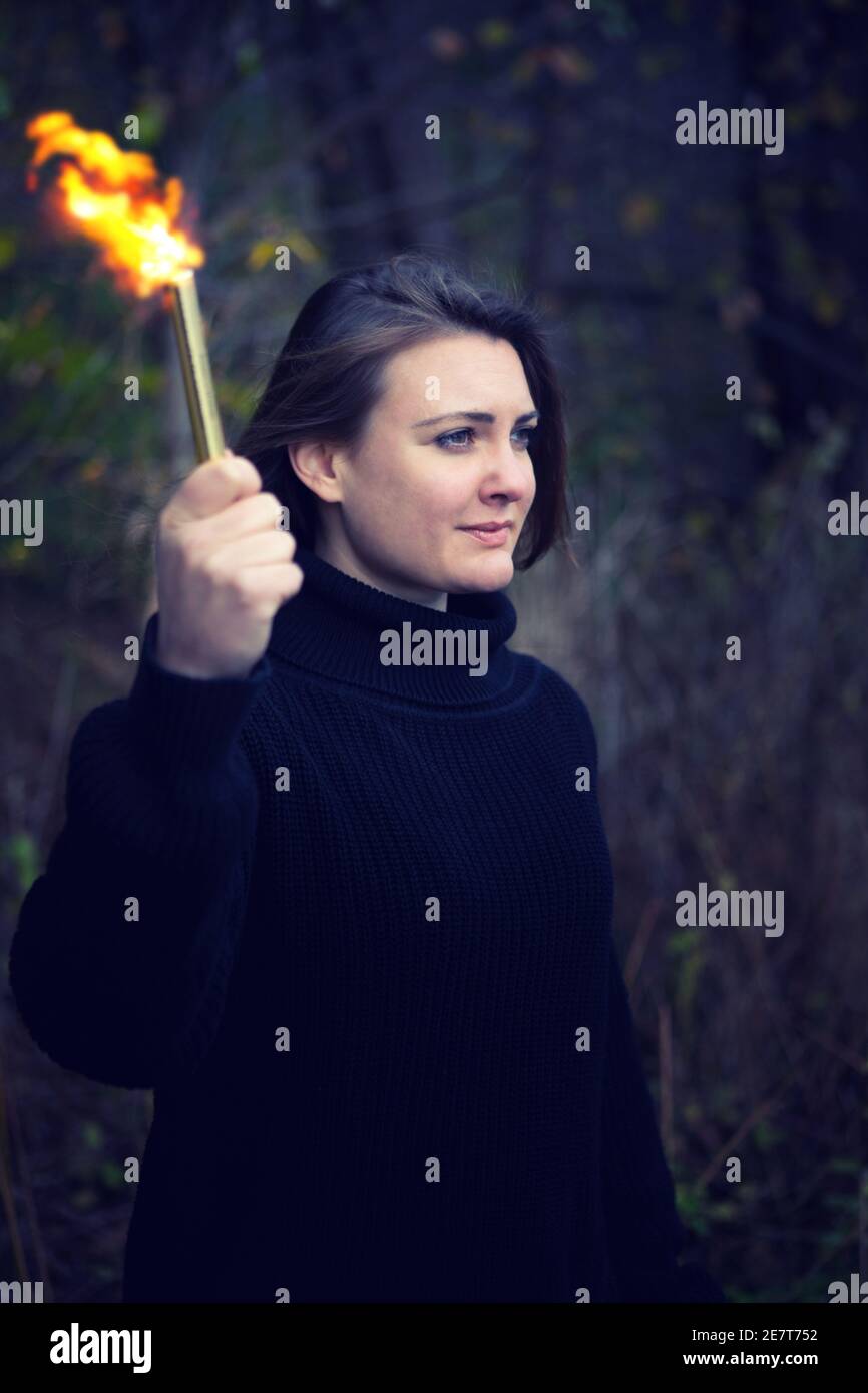 portrait of brunette woman in the dark holding a torch Stock Photo - Alamy
