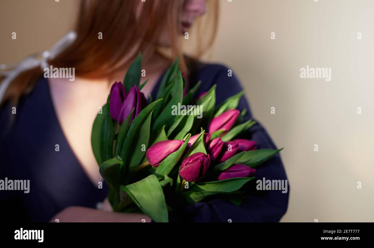Long hair attractive girl holding beautiful spring bouquet of tulips ...