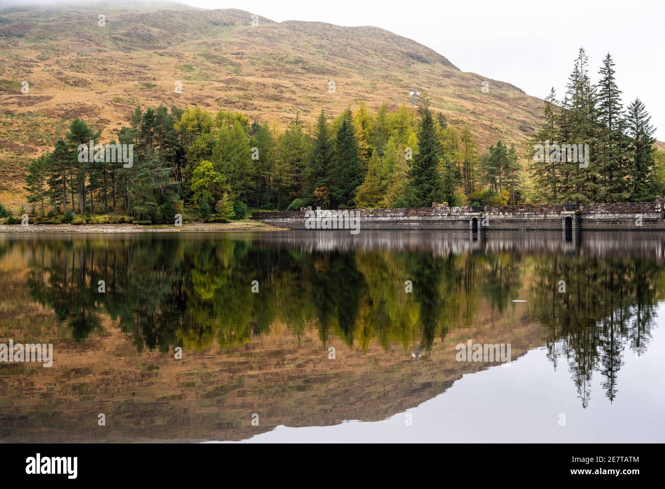 Loch Arklet dam reflected in the still waters of Loch Arklet in the ...