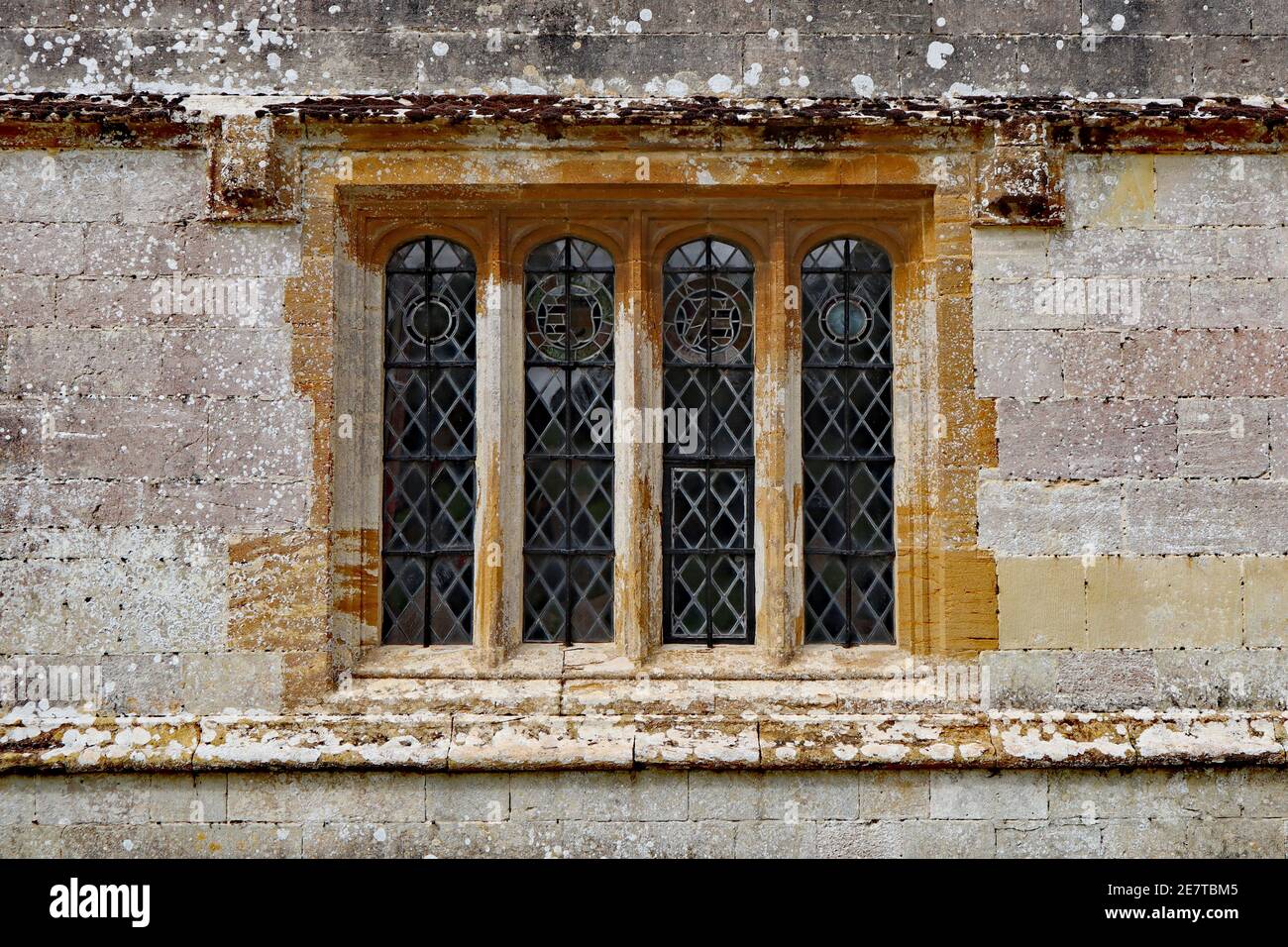 An old leaded window with a concrete frame in an old English country ...