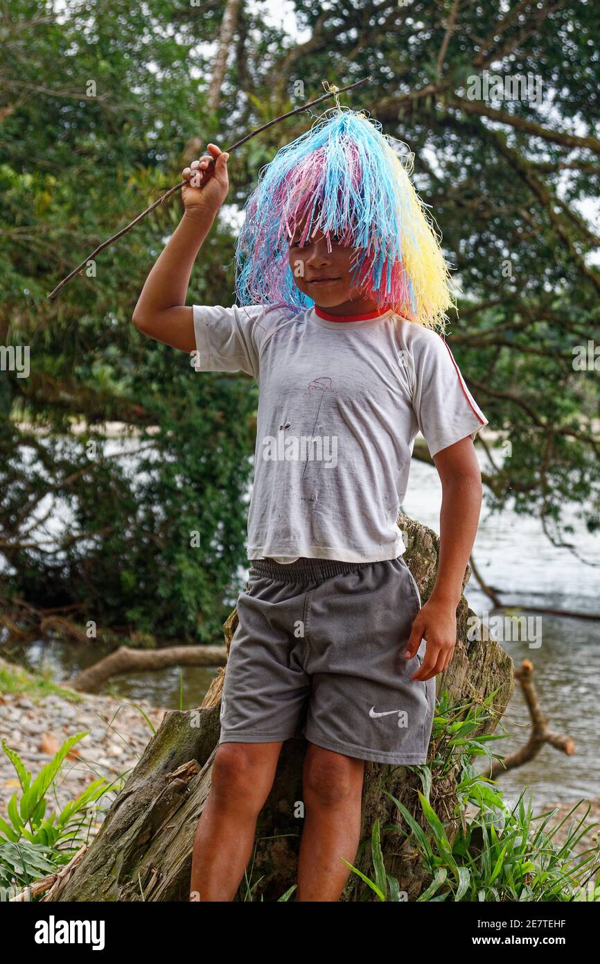 young boy holding multicolored strings over head; cute; playful; darker ...