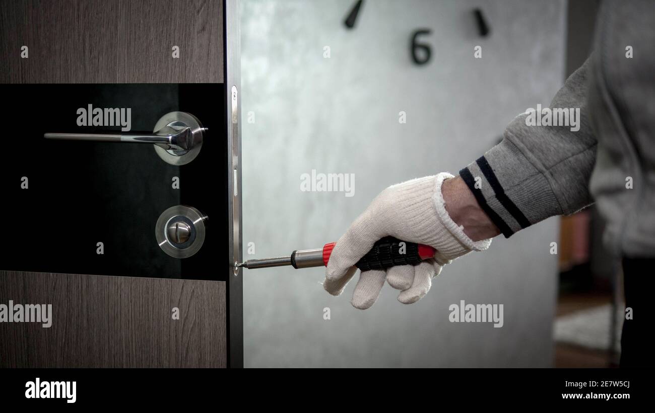 A carpenter installs a door lock on an interior door, a handyman ...