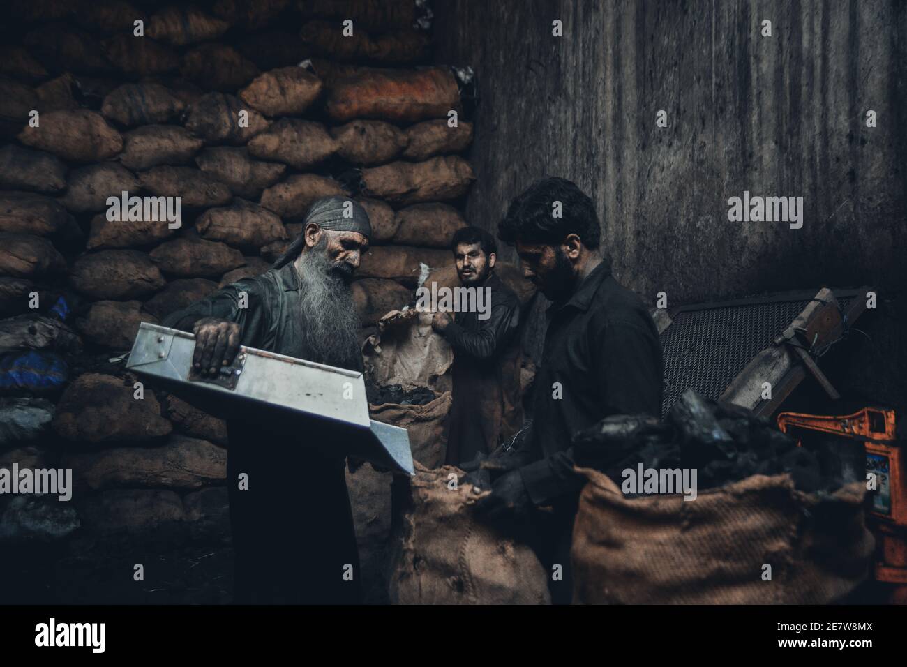 Hard-working men loading & packing coal with bare hands for consumer ...