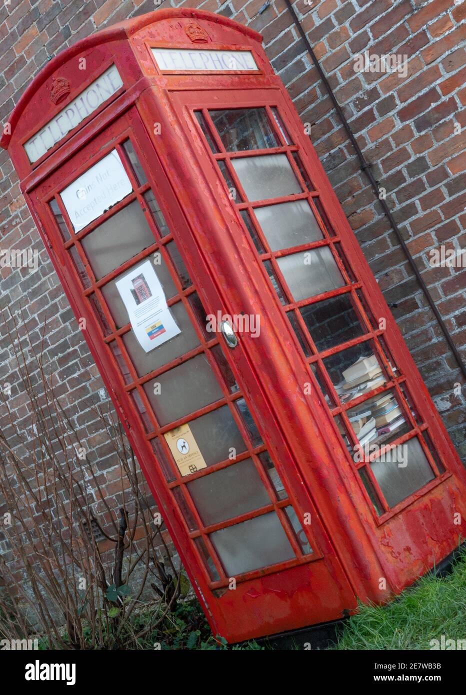 bright red british old telephone box converedt to a village book swap ...