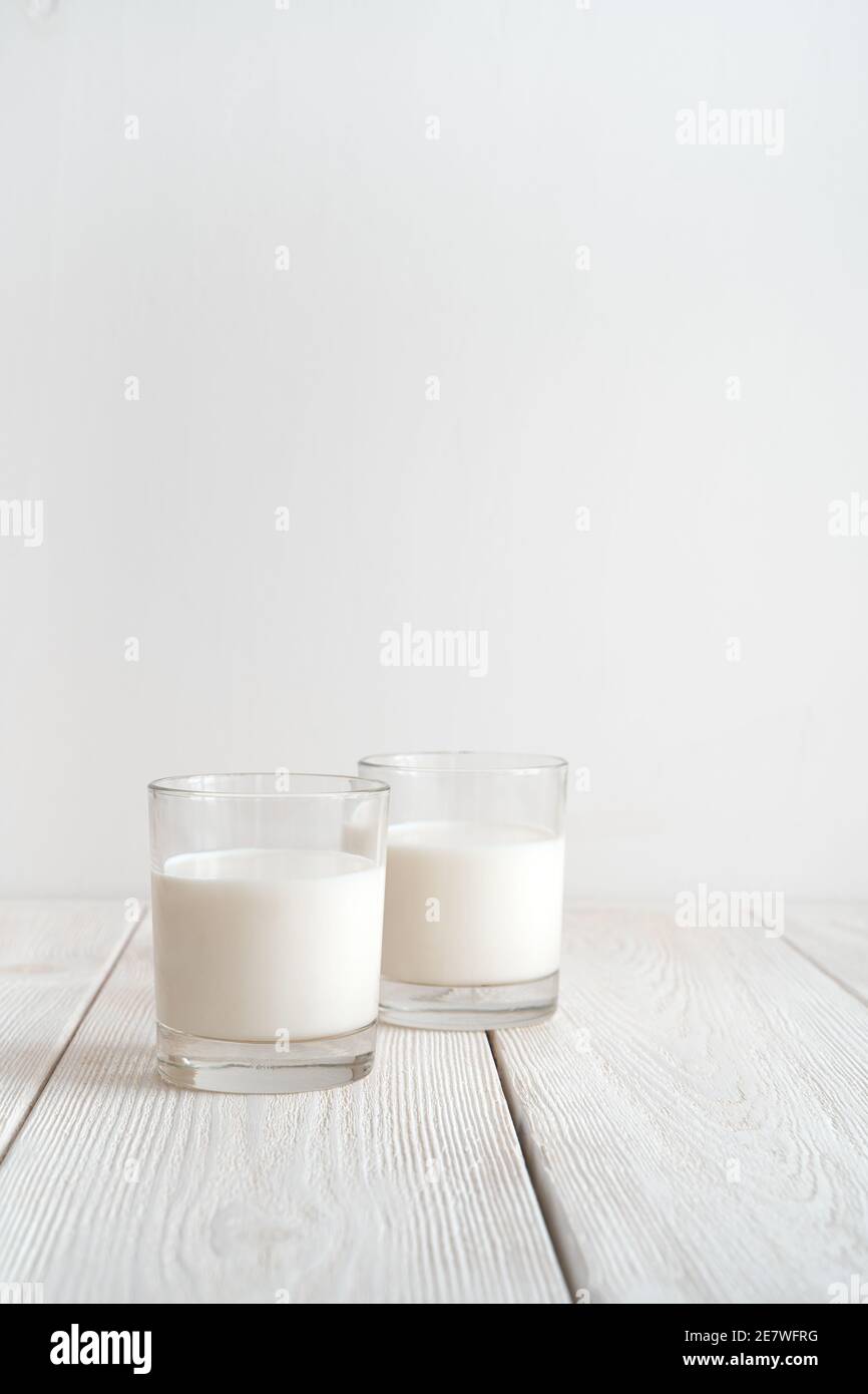 Two glasses of milk on a white background. Side view with copy space ...