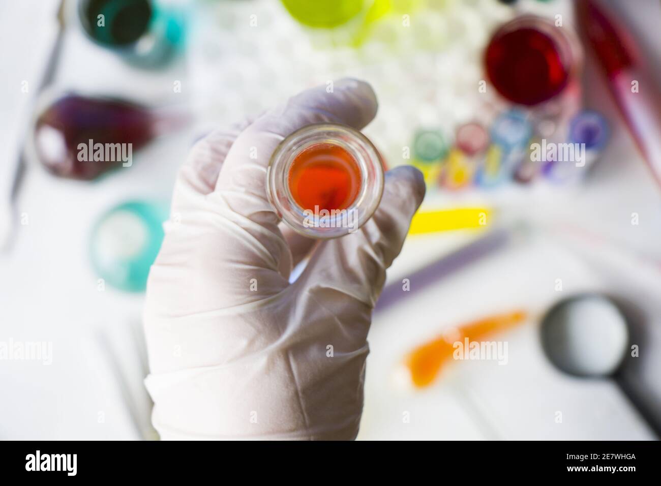 Top view shot of a laboratory glass reagent with an orange liquid in a ...