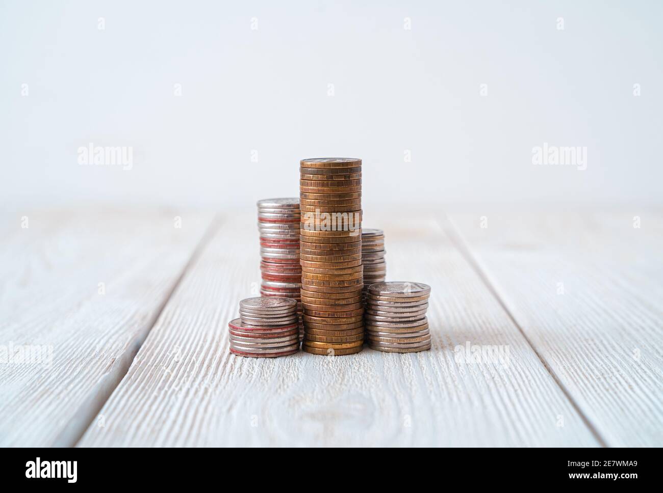 Coins in stacks in the form of towers on a light background. Side view ...