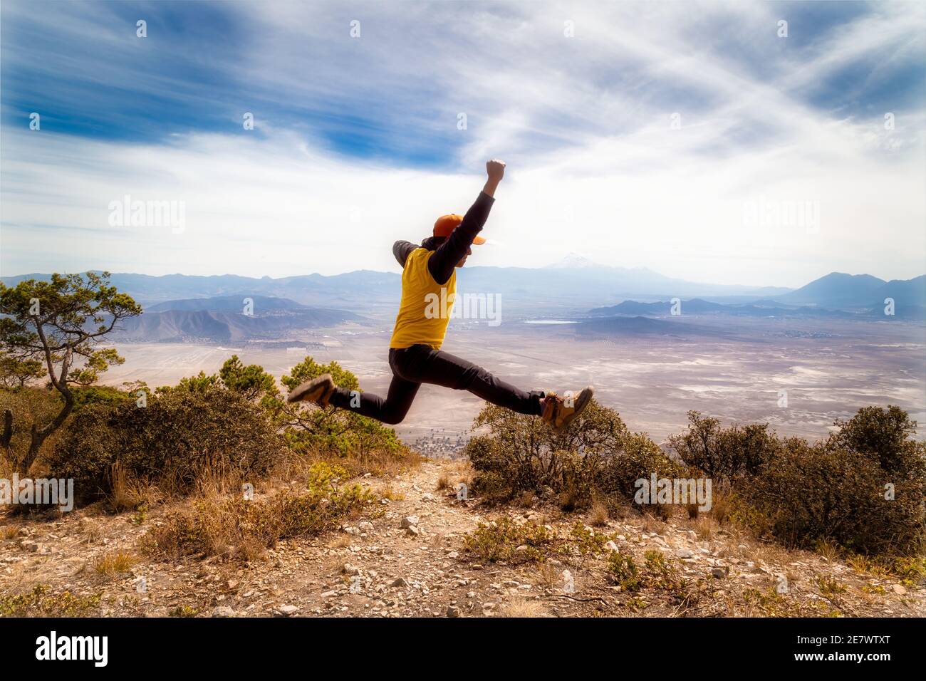 Hiker jumping on top of the hill with a beautiful vie Stock Photo - Alamy