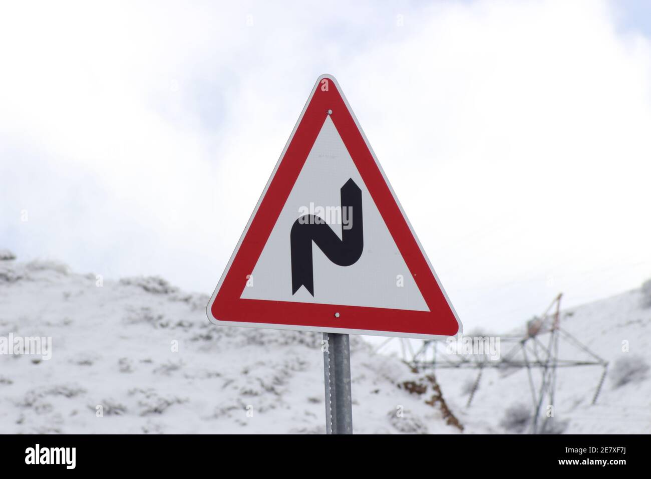 Bendy road warning in traffic Stock Photo - Alamy