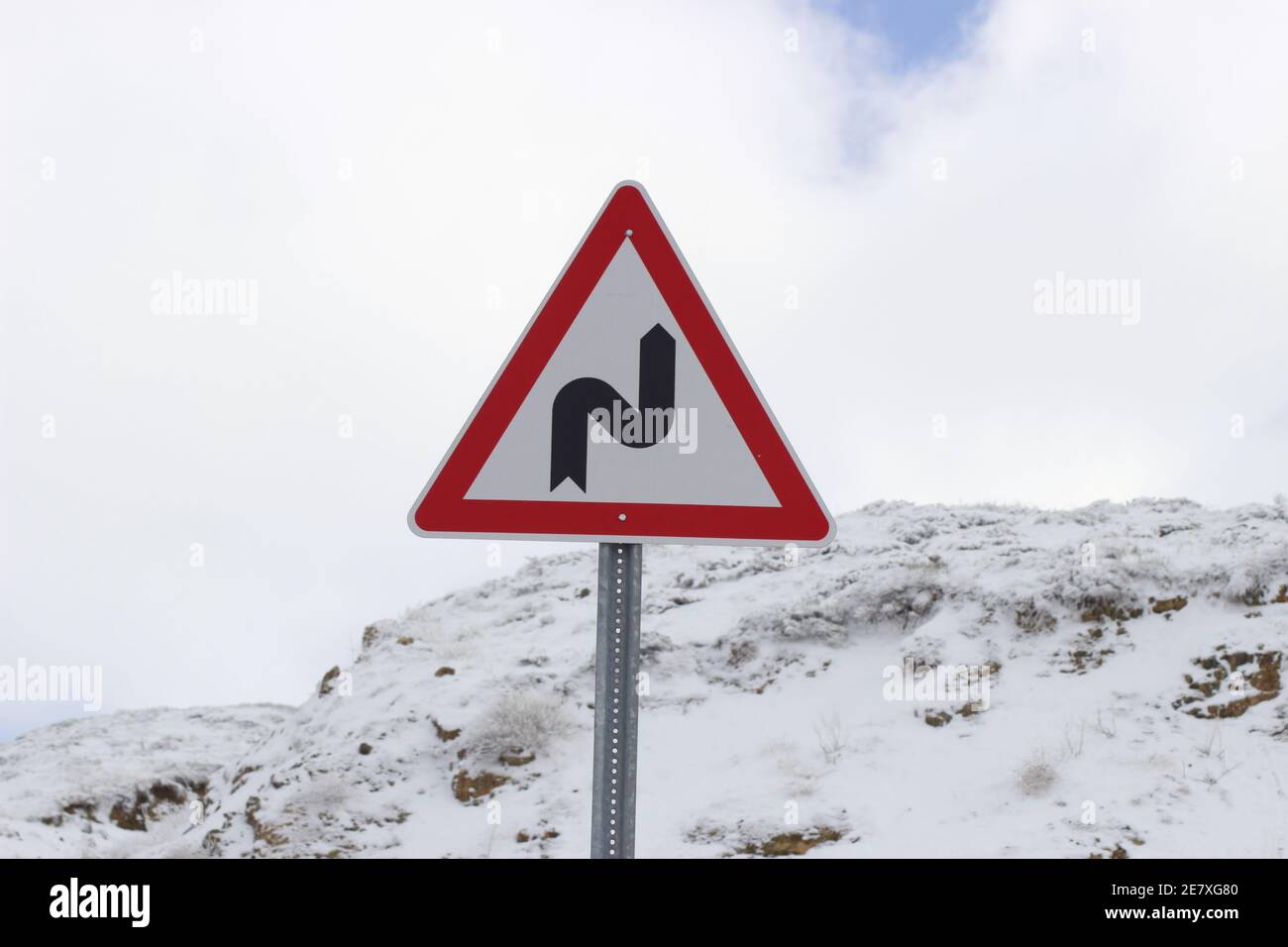 Bendy road warning in traffic Stock Photo - Alamy