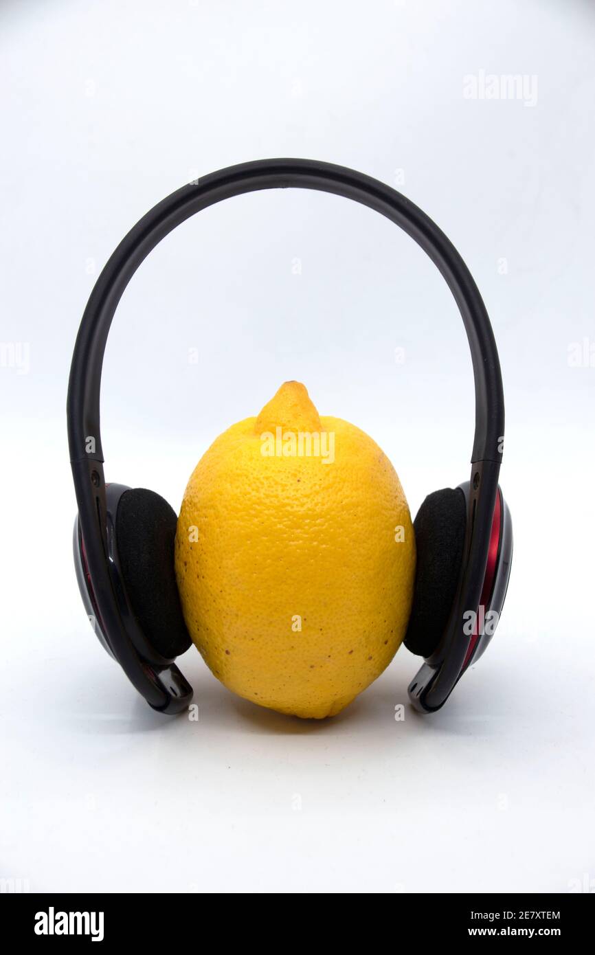 Yellow lemon in headphones on a white background Stock Photo - Alamy