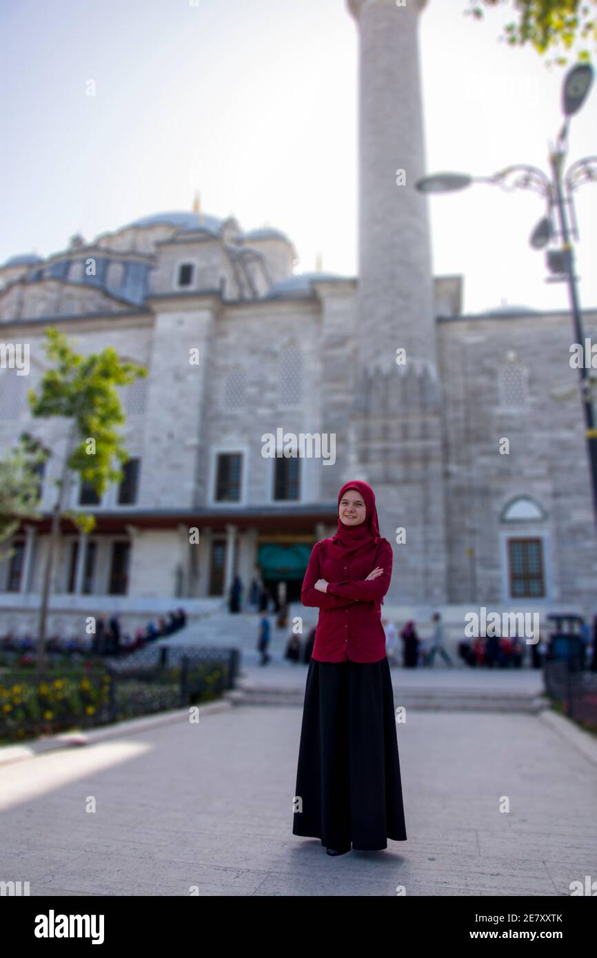 Muslim tourist girl posing in front of ancient Fatih mosque in Istanbul ...