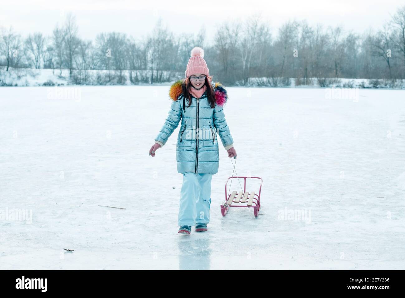 Winter walk. Beautiful caucasian girl on ice in the snow. Girl in a ...