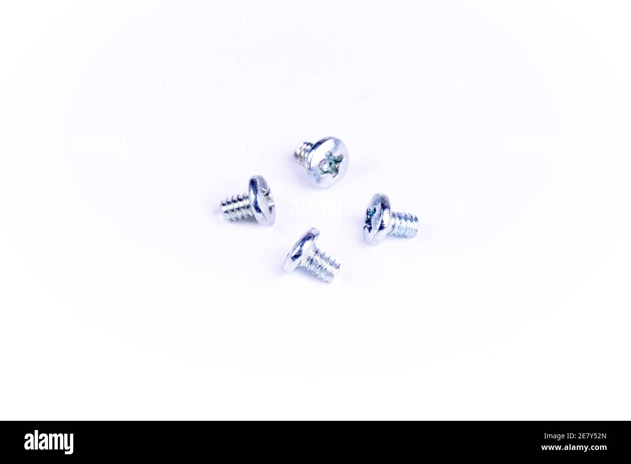 four silver colored screws on white background. screws used for ...