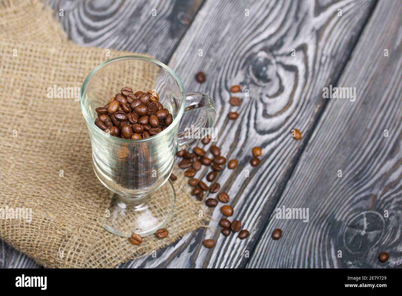 Coffee beans. Poured into a glass beaker. Stands on linen and pine ...