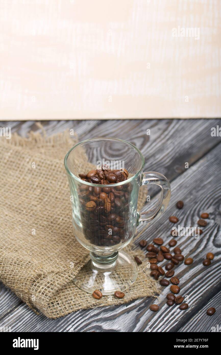 Coffee beans. Poured into a glass beaker. Stands on linen and pine ...
