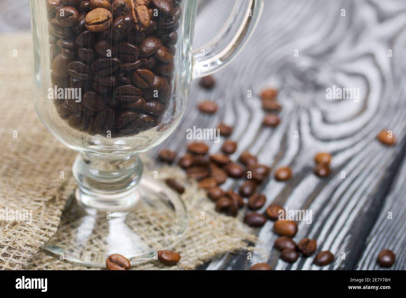 Coffee beans. Poured into a glass beaker. Stands on linen and pine ...