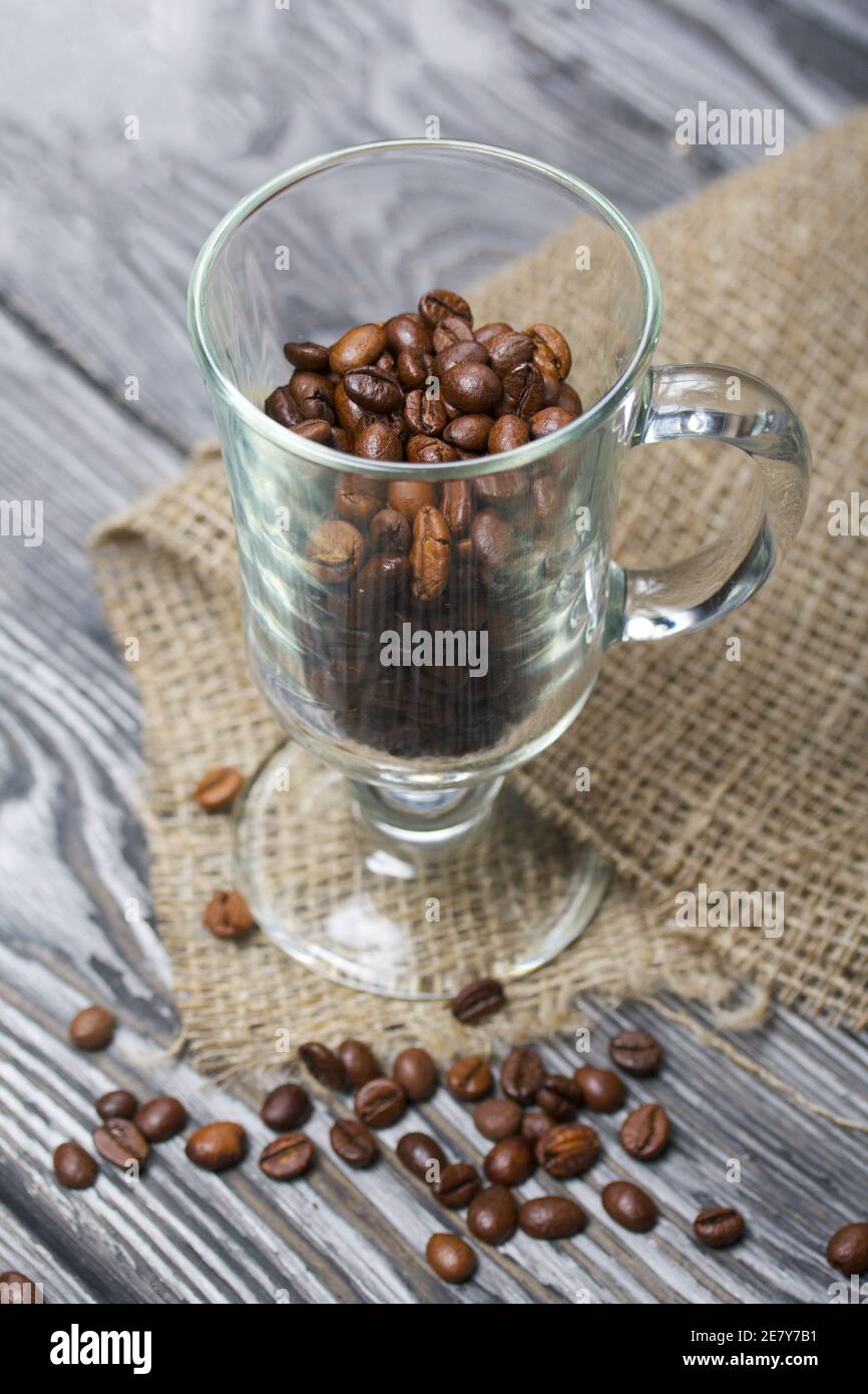 Coffee beans. Poured into a glass beaker. Stands on linen and pine ...