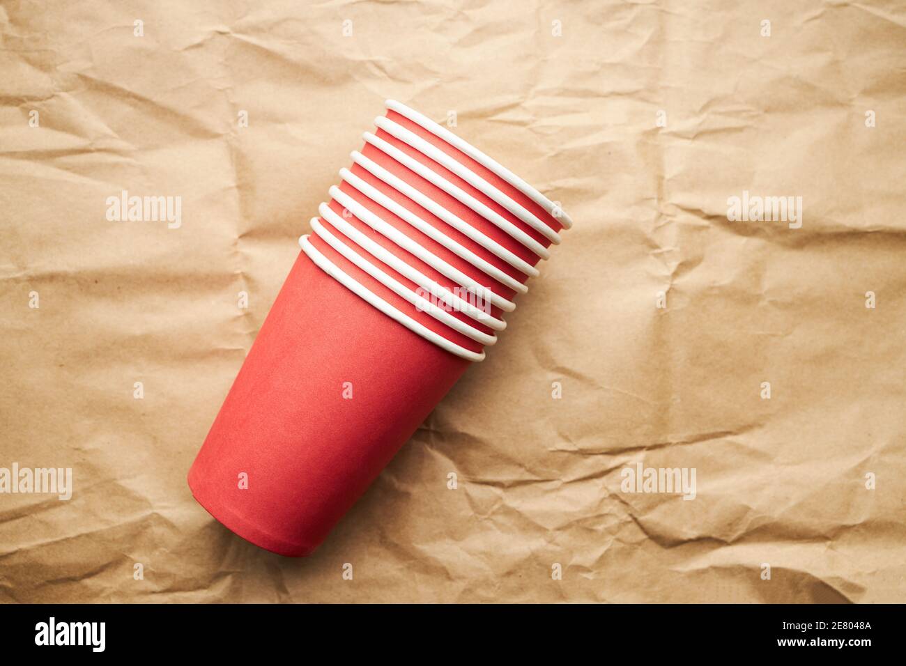 stack of disposable red paper cups on paper background. eco friendly ...