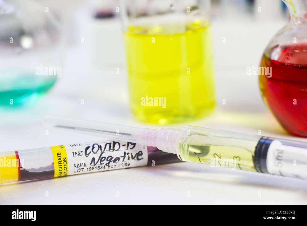 Closeup shot of a blood sample test and a syringe on glass flasks ...