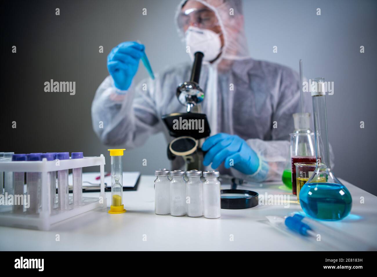 Biochemistry laboratory research, chemist in protective suit analyzing ...