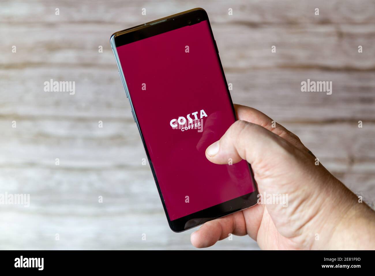 A hand holding a mobile phone or cell phone with the Costa Coffee app ...