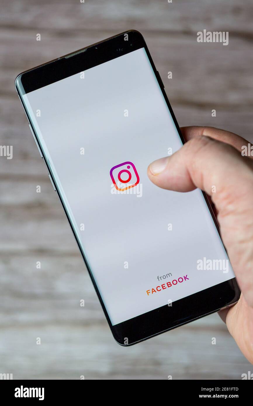A hand holding a mobile phone or cell phone with the Instagram app open ...