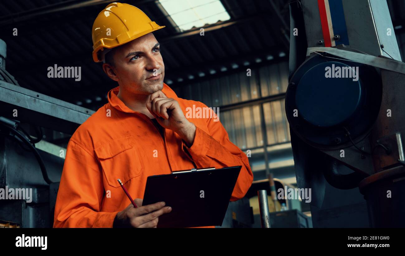 Skillful factory worker working with clipboard to do job procedure ...