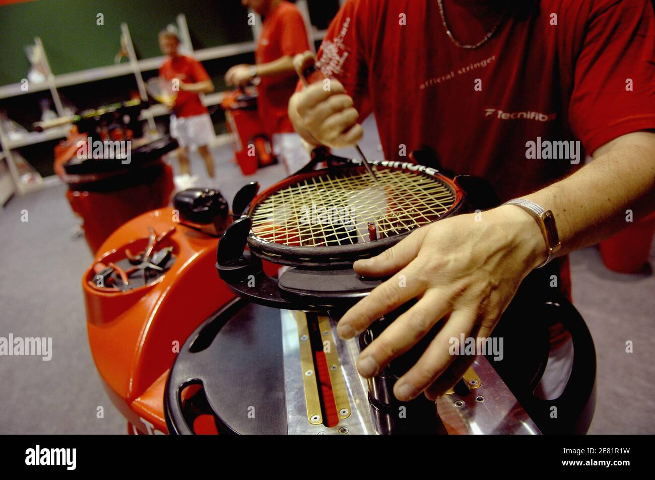Specialized workers prepare stringing of tennis player's rackets before ...