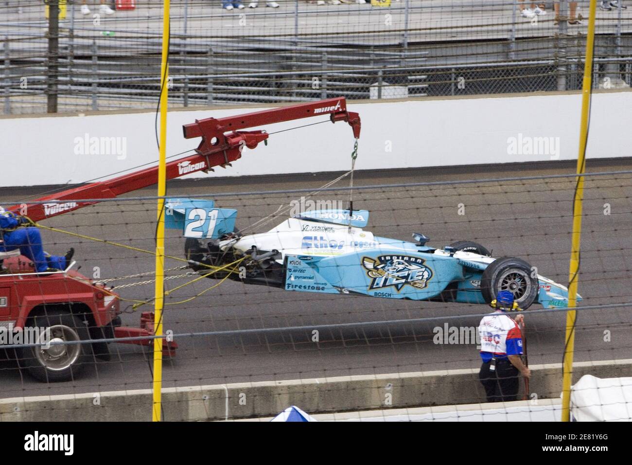 Track workers tow Jaques Lazier's car after he hit the wall on the ...