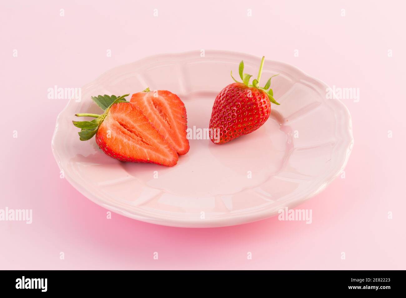 Fresh strawberry on plate on a pink background Stock Photo - Alamy