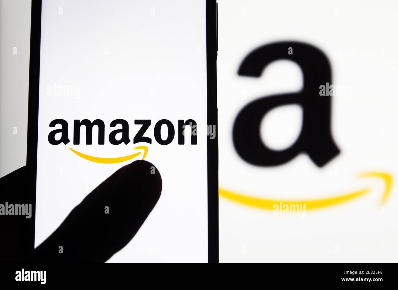 In this photo illustration an Amazon, logo seen displayed on a mobile ...