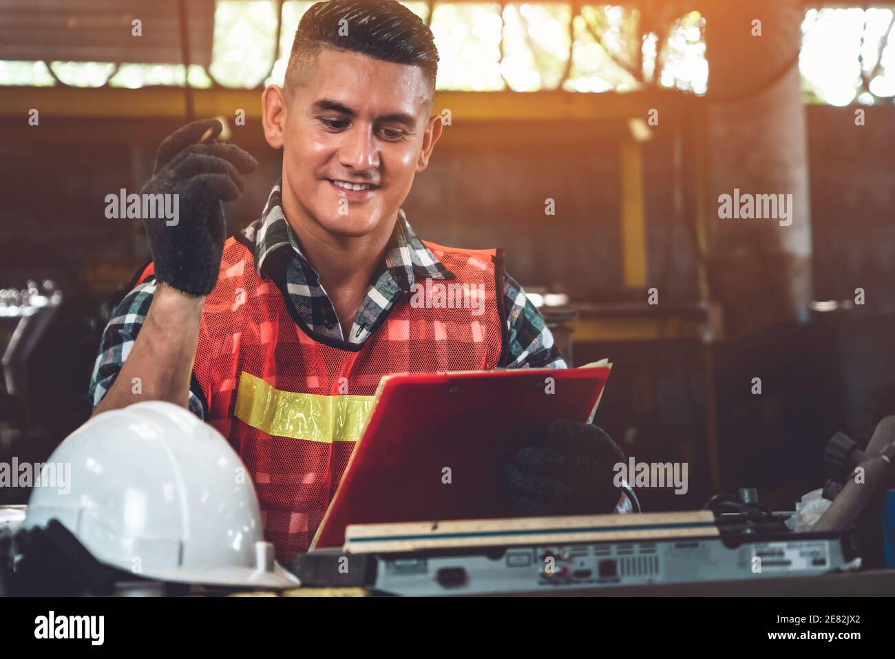 Manufacturing worker working with clipboard to do job procedure ...