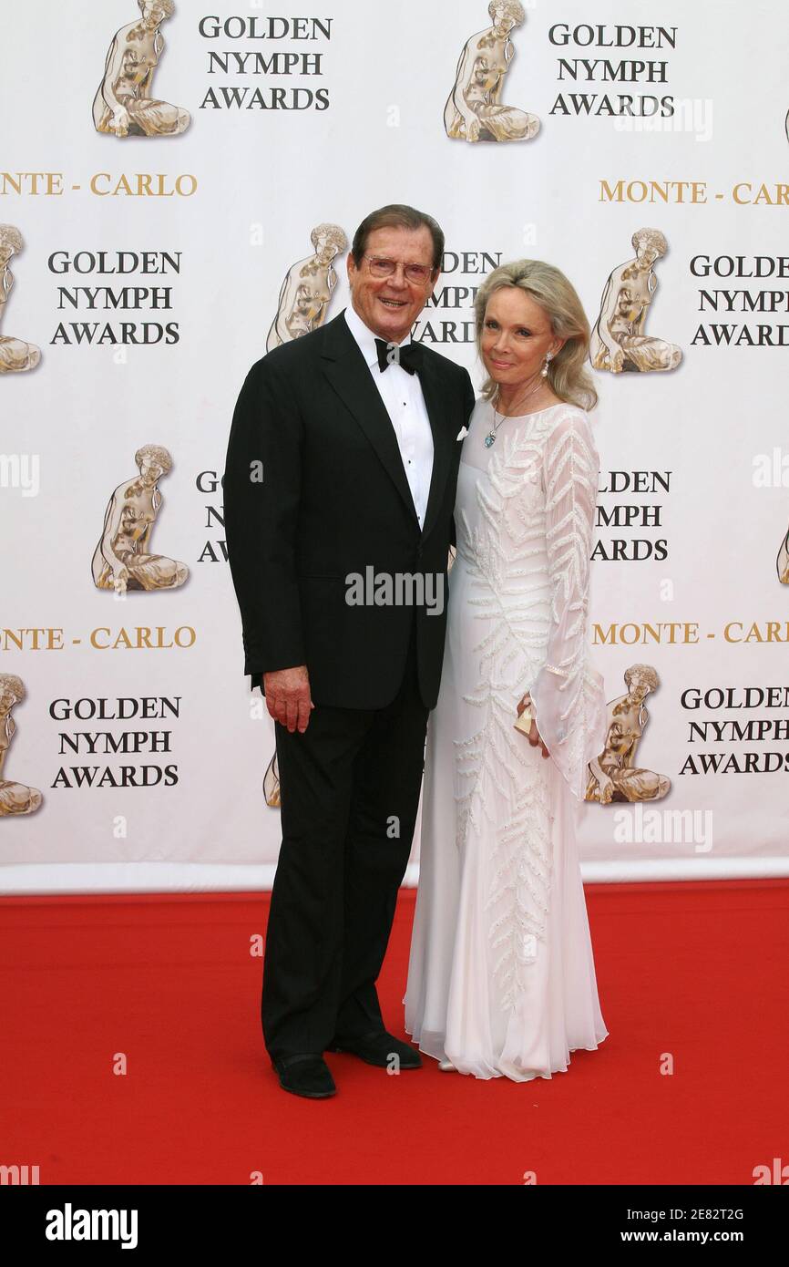 Sir Roger Moore and his wife pose for pictures during the closing ...