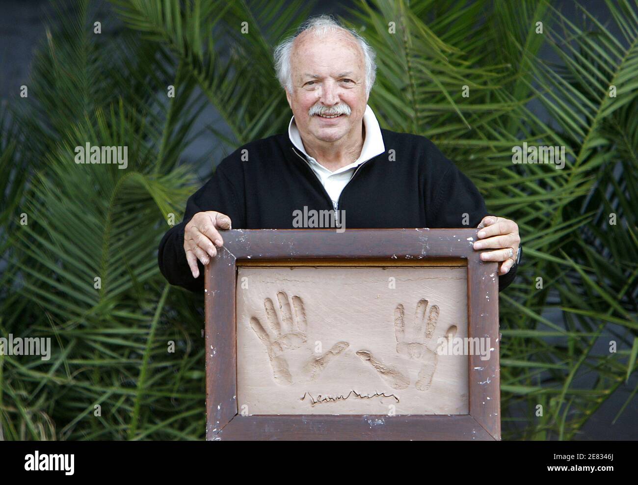 Jean Becker poses with his handprints in the clay during the '25th ...