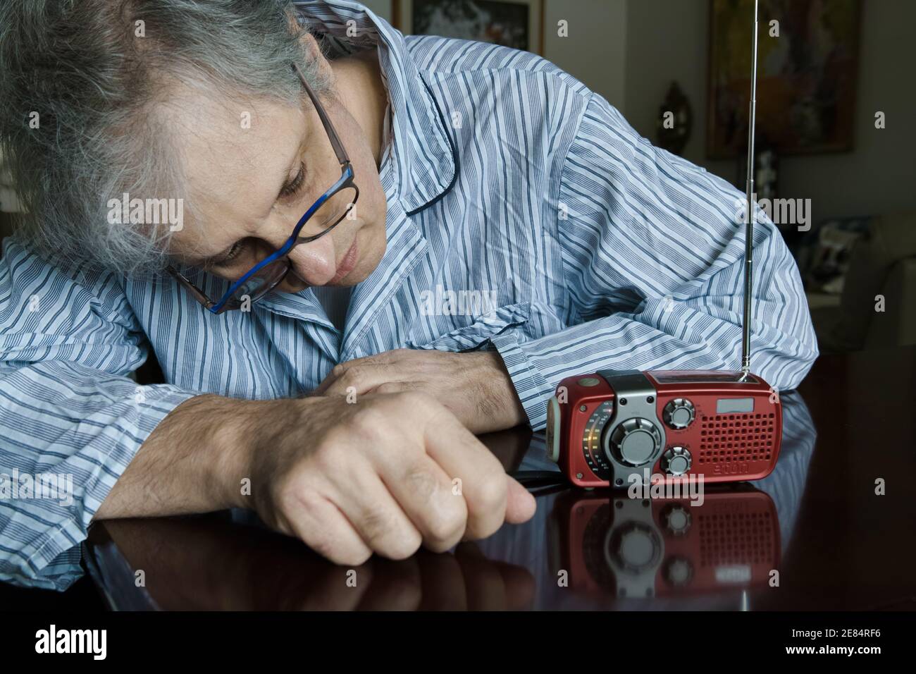 Mature male observing the small radio set Stock Photo - Alamy