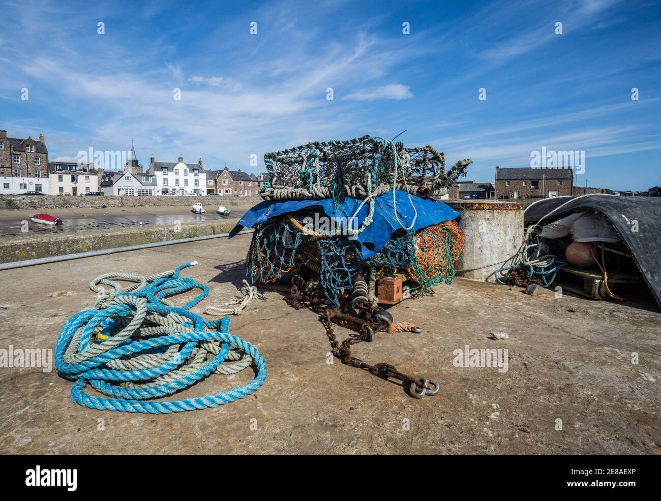 Fishing nets, ropes and baskets on a quay in Stonehaven harbour, a town ...