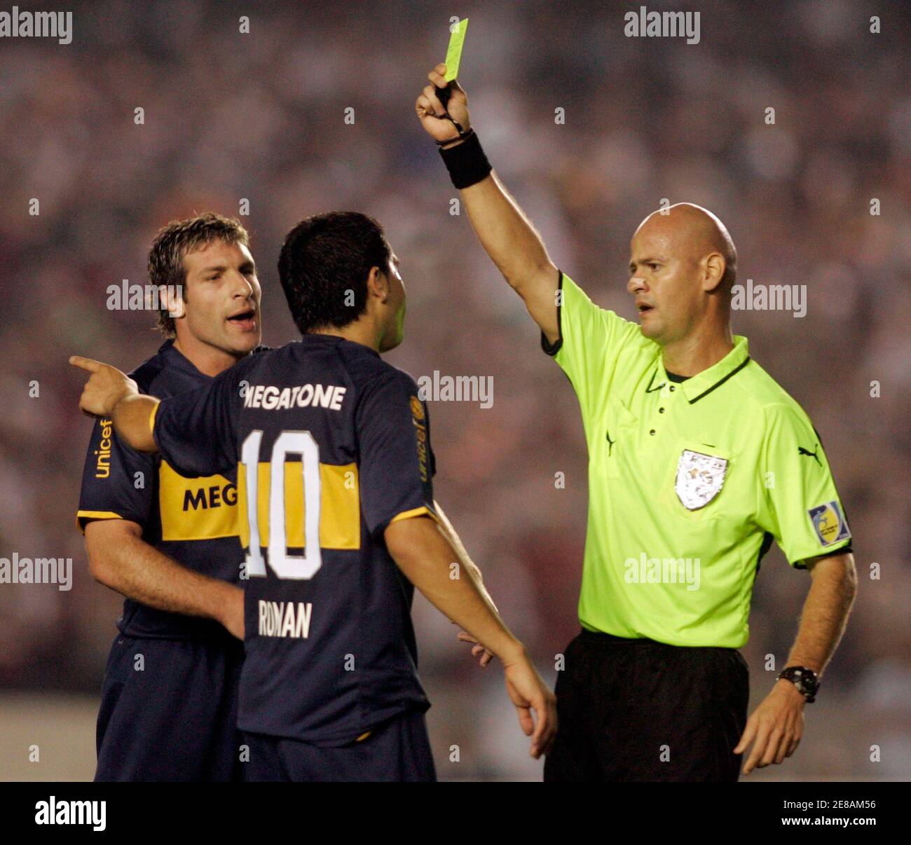 Referee Carlos Torres shows a yellow card to Boca Juniors' Juan Roman ...