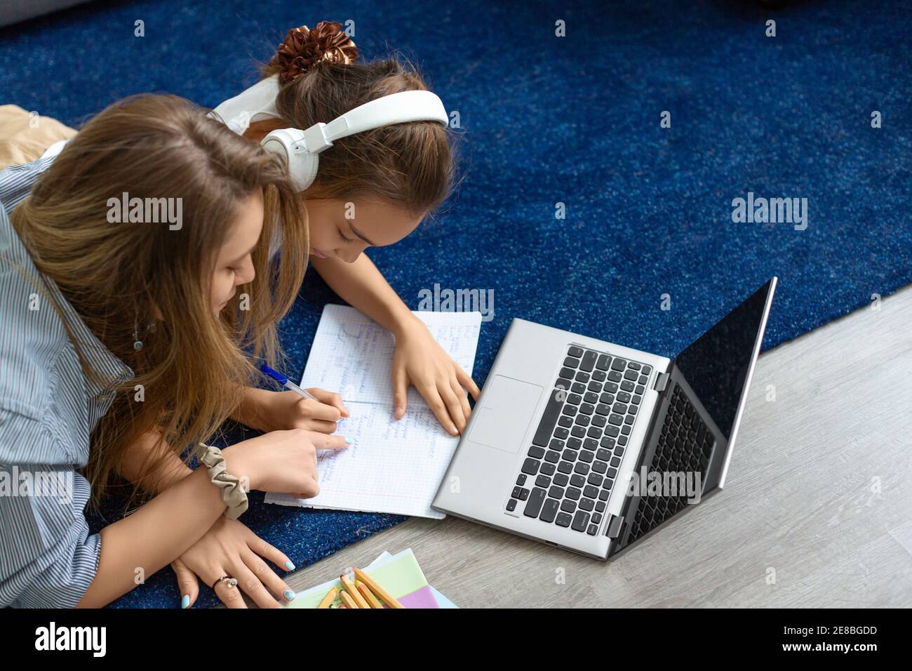Mom helps her daughter to do homework in front of a laptop monitor ...