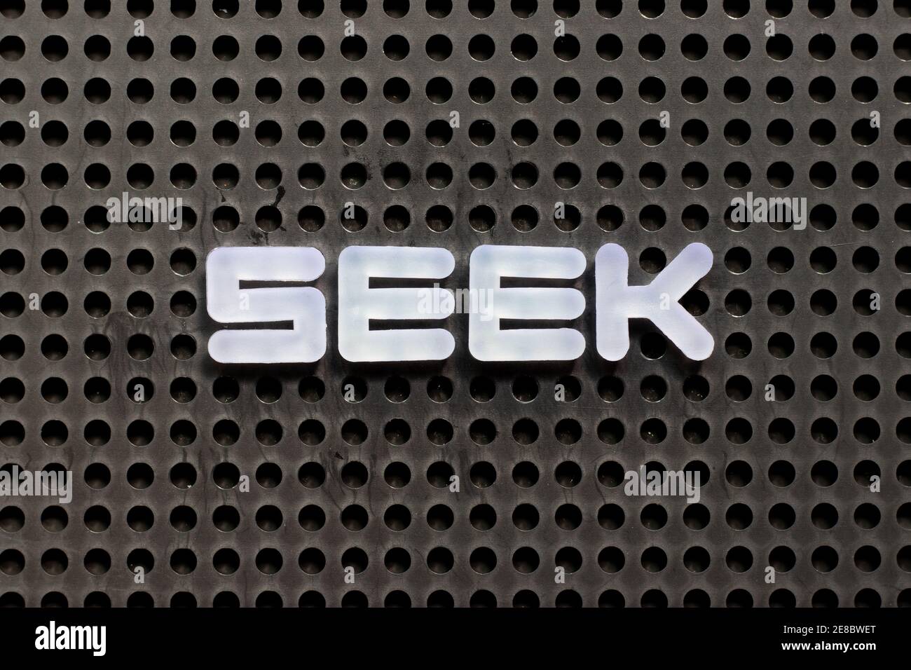 White color letter in word seek on black pegboard background Stock ...