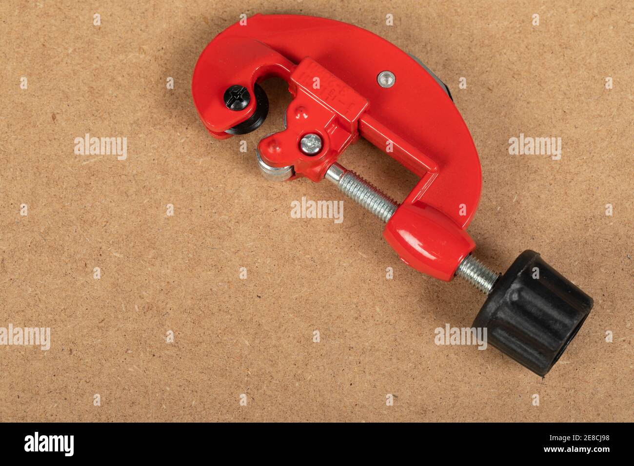 Cutting a copper pipe with a red pipe cutter Stock Photo - Alamy