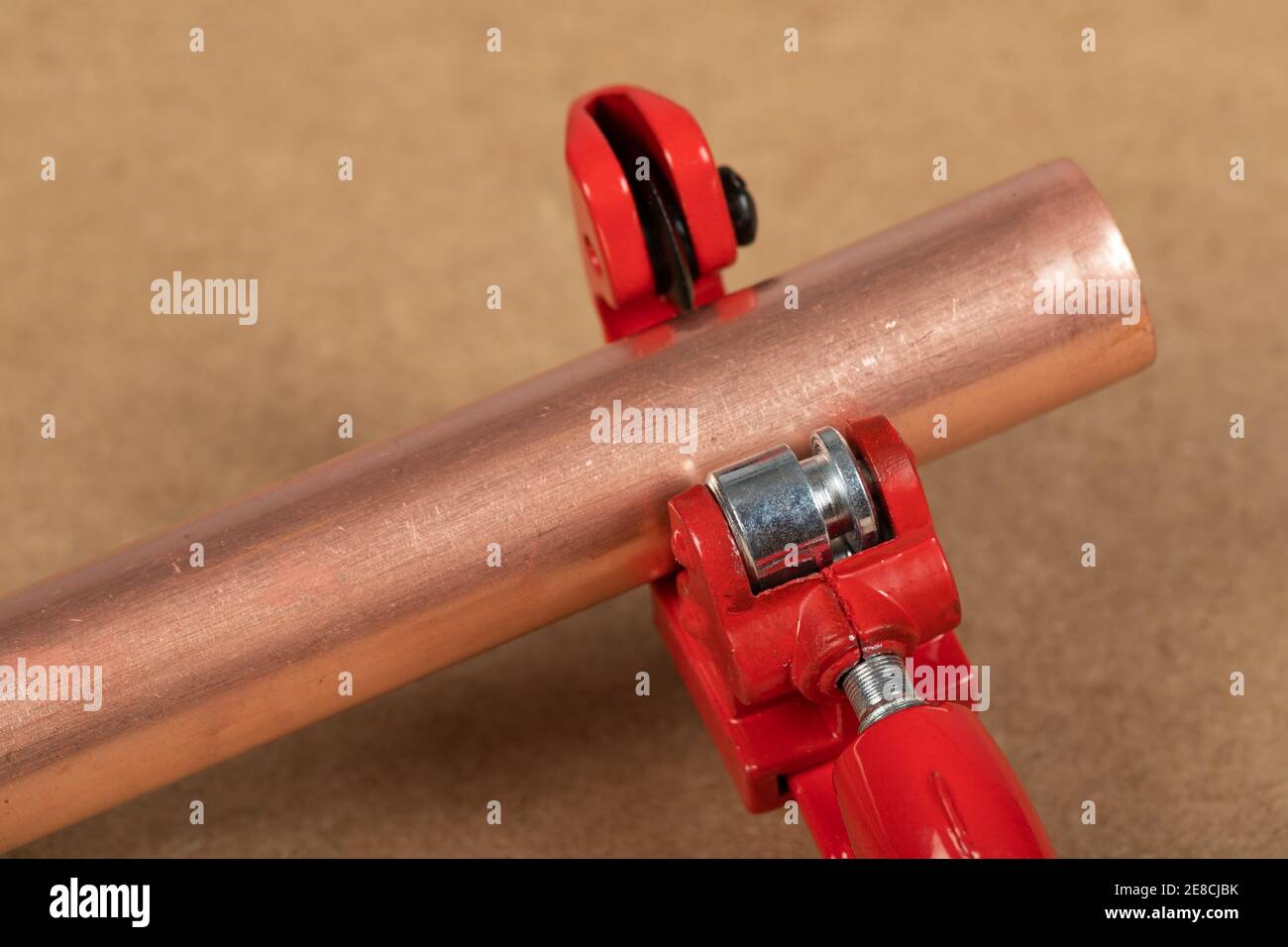 Cutting a copper pipe with a red pipe cutter Stock Photo - Alamy