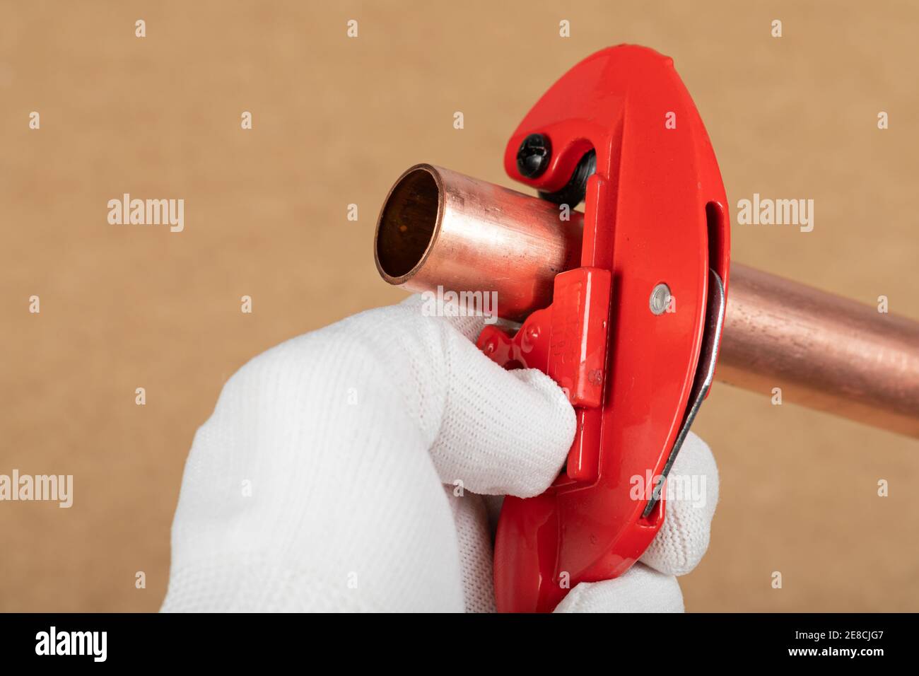 Cutting a copper pipe with a red pipe cutter Stock Photo - Alamy