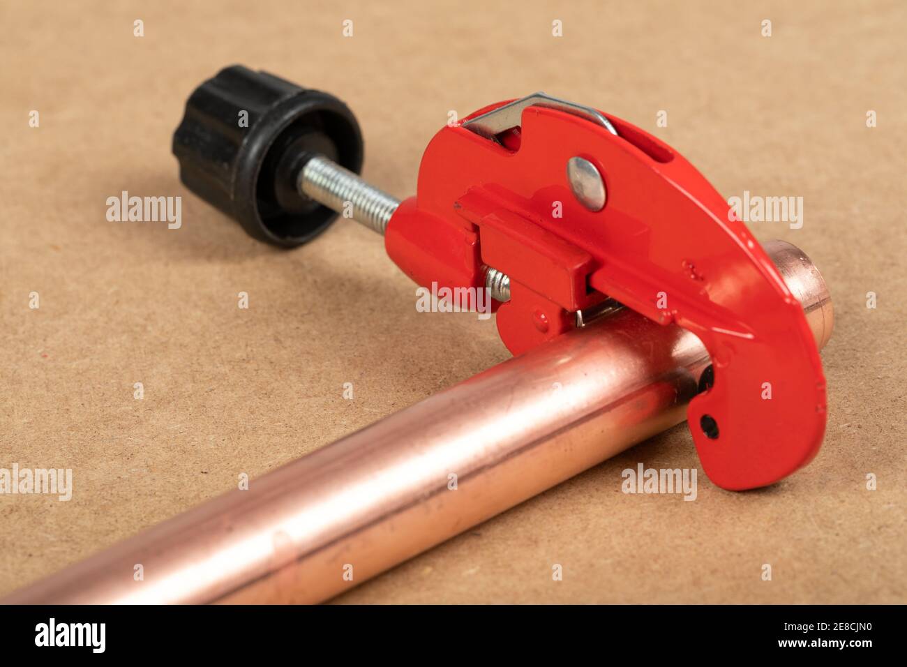 Cutting a copper pipe with a red pipe cutter Stock Photo - Alamy