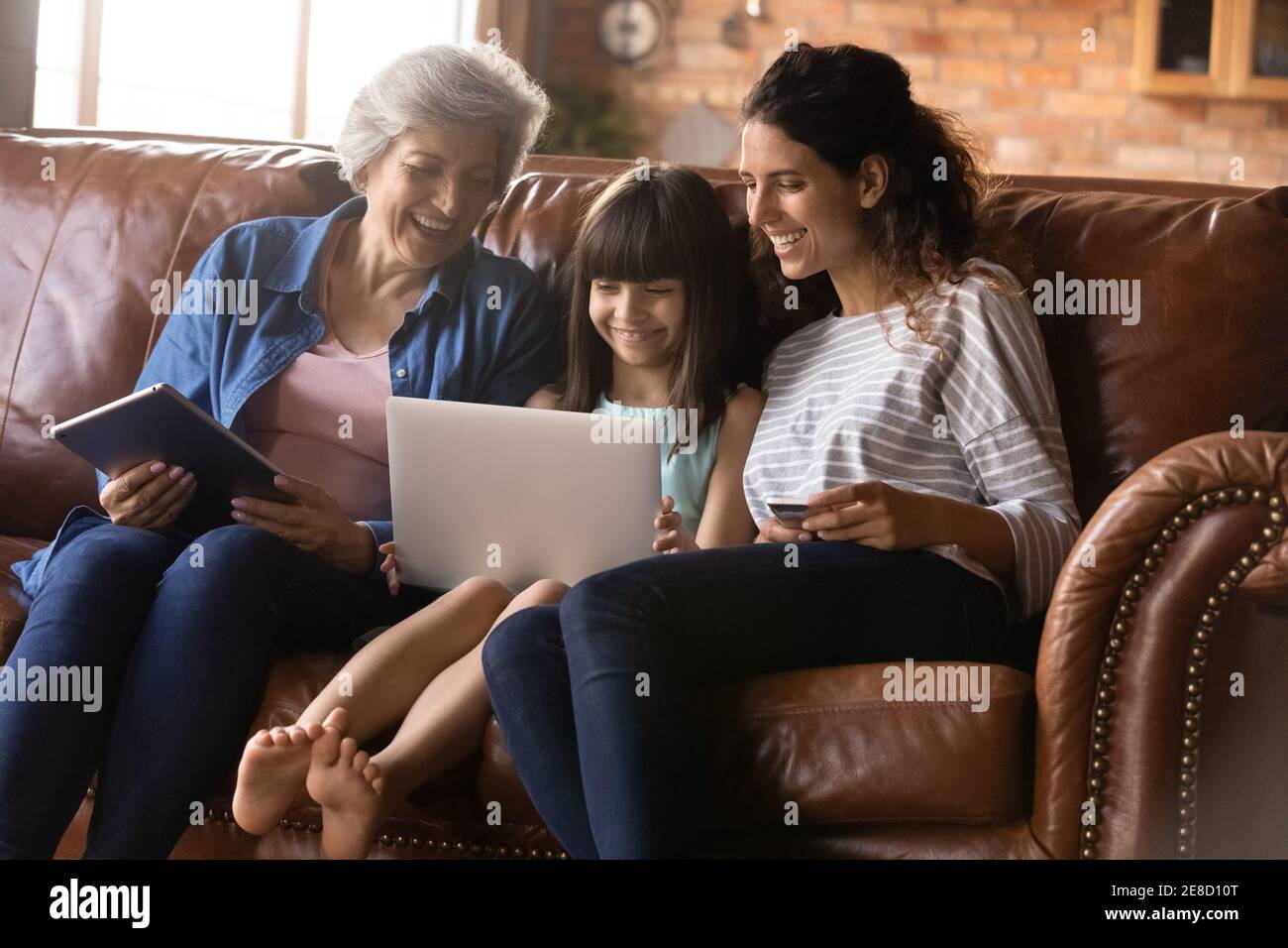 Happy three generations of women having fun with gadgets together Stock ...